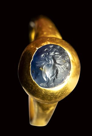 A late roman blue sapphire intaglio set in a gold ring. Peacock. 4th ...